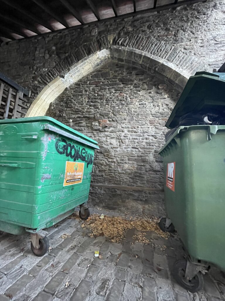 The medieval arcade now hidden behind a bin store
